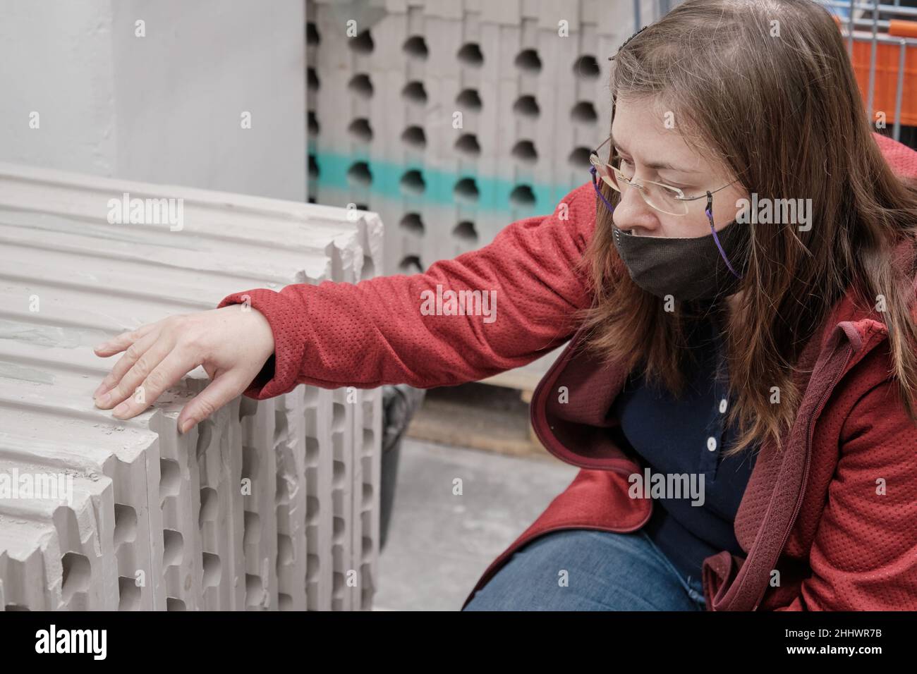 Woman wearing mask against virus buys foam concrete in building ...