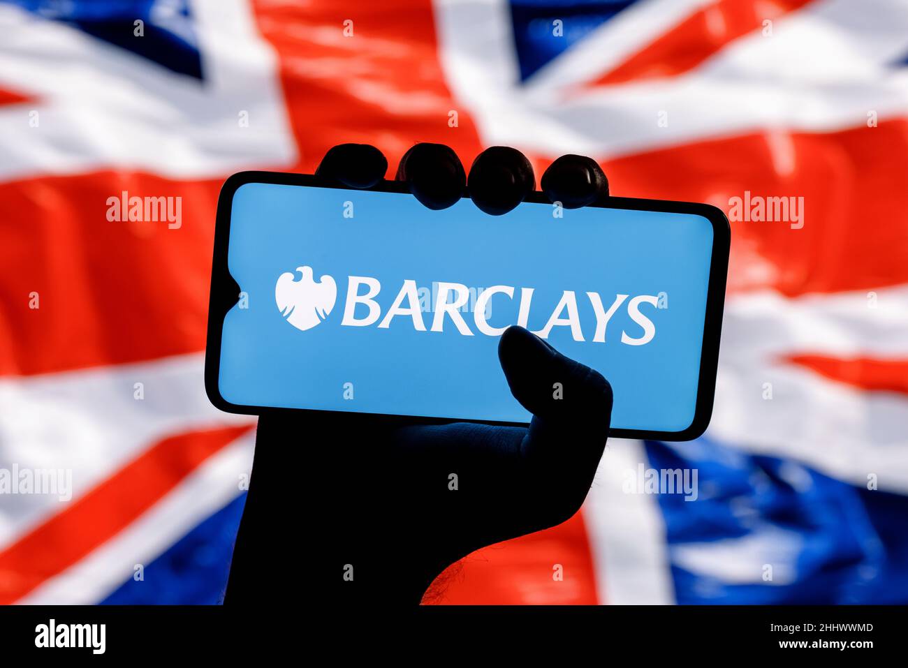 Smartphone with Barclays bank logo in clenched hand on background of ...