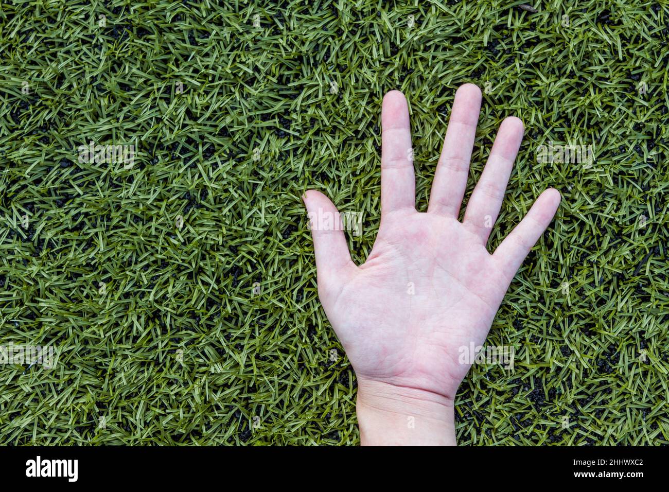 girl hand on soccer field grass background Stock Photo - Alamy