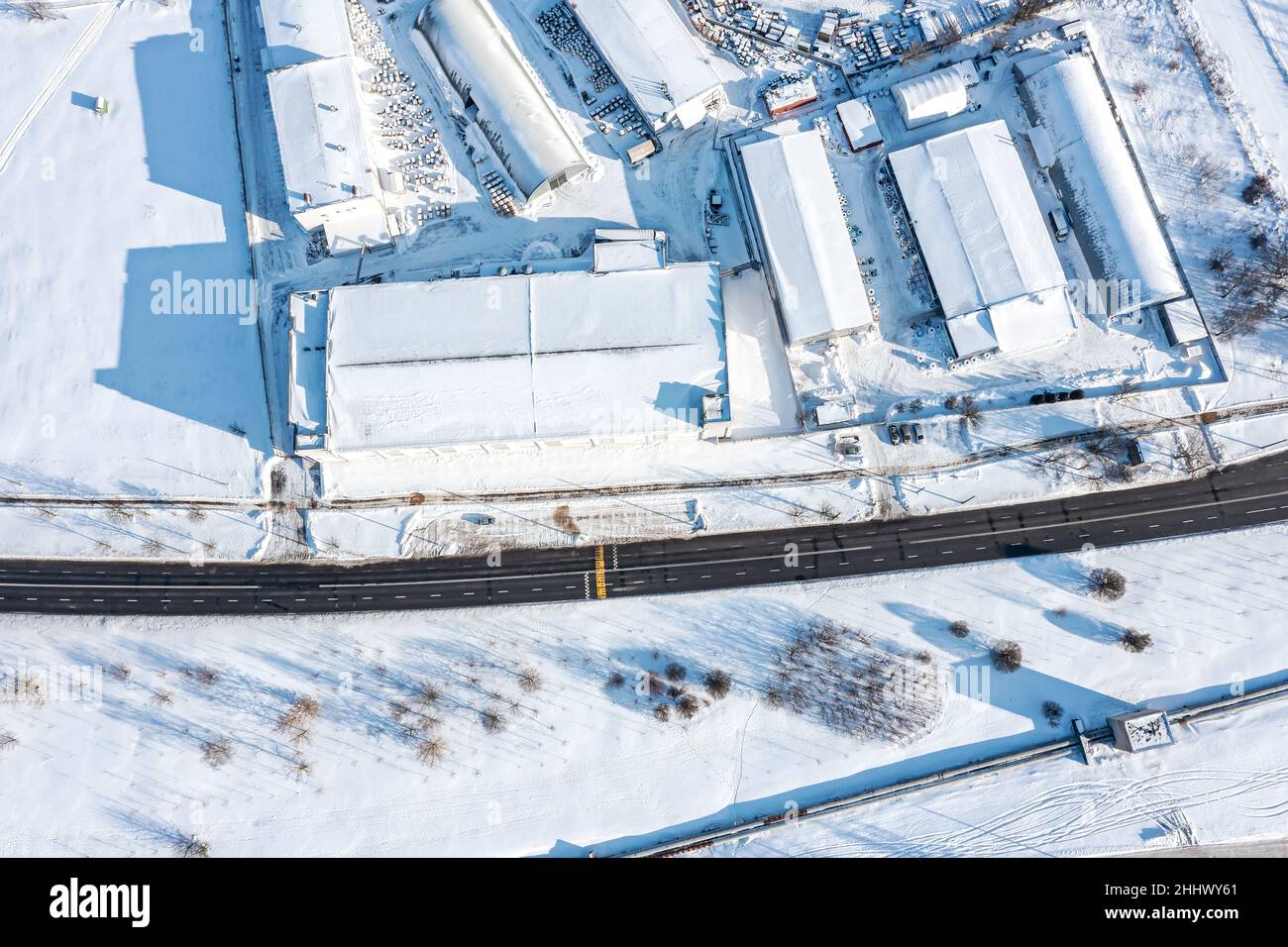 aerial top view of snow-covered storage buildings and warehouses in an ...