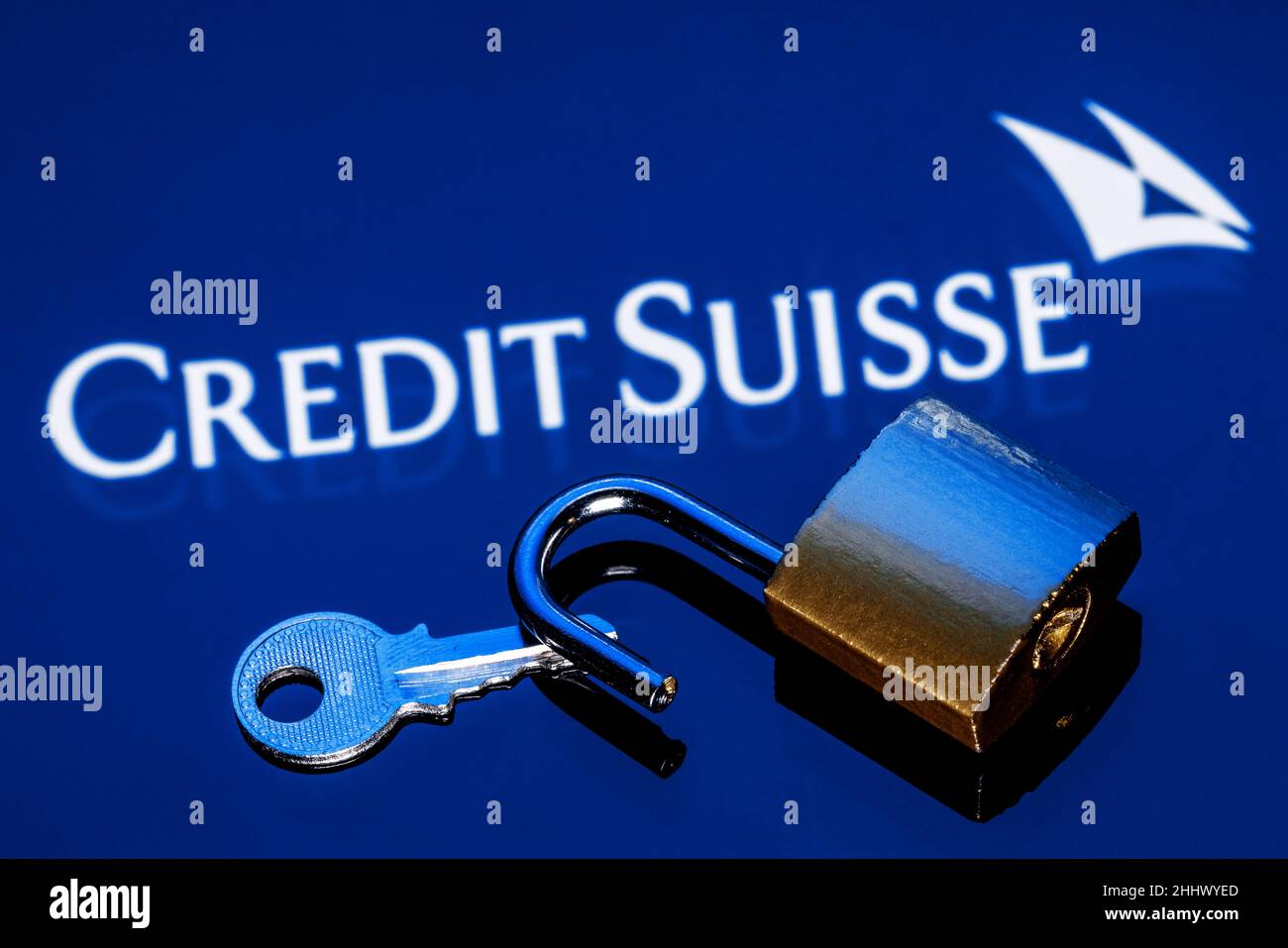 An open security lock and key on background of Credit Suisse bank logo ...