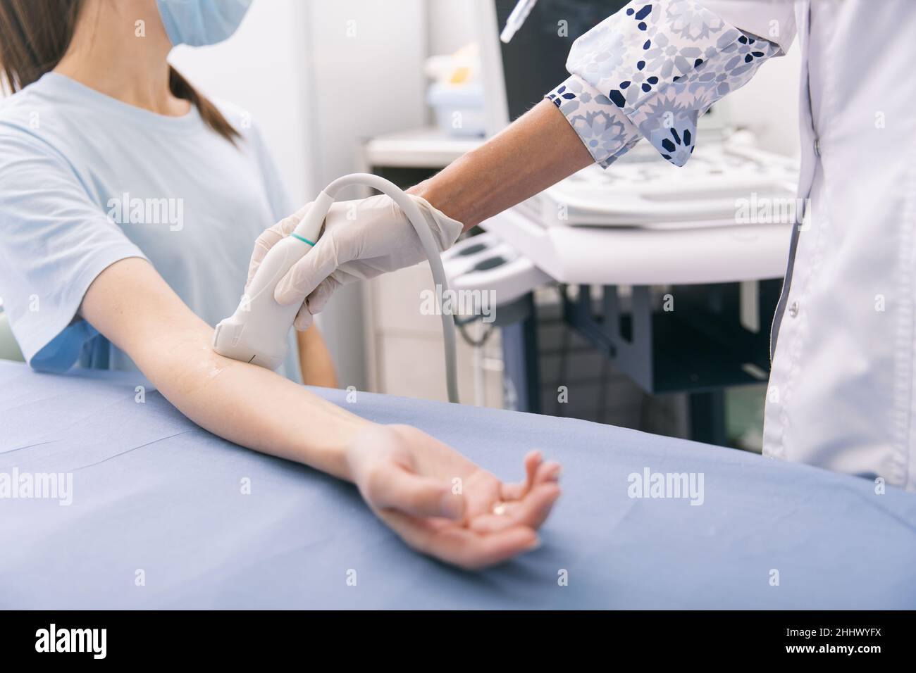 Doctor doing the ultrasound on the hand close up. Doctor demonstrates ...