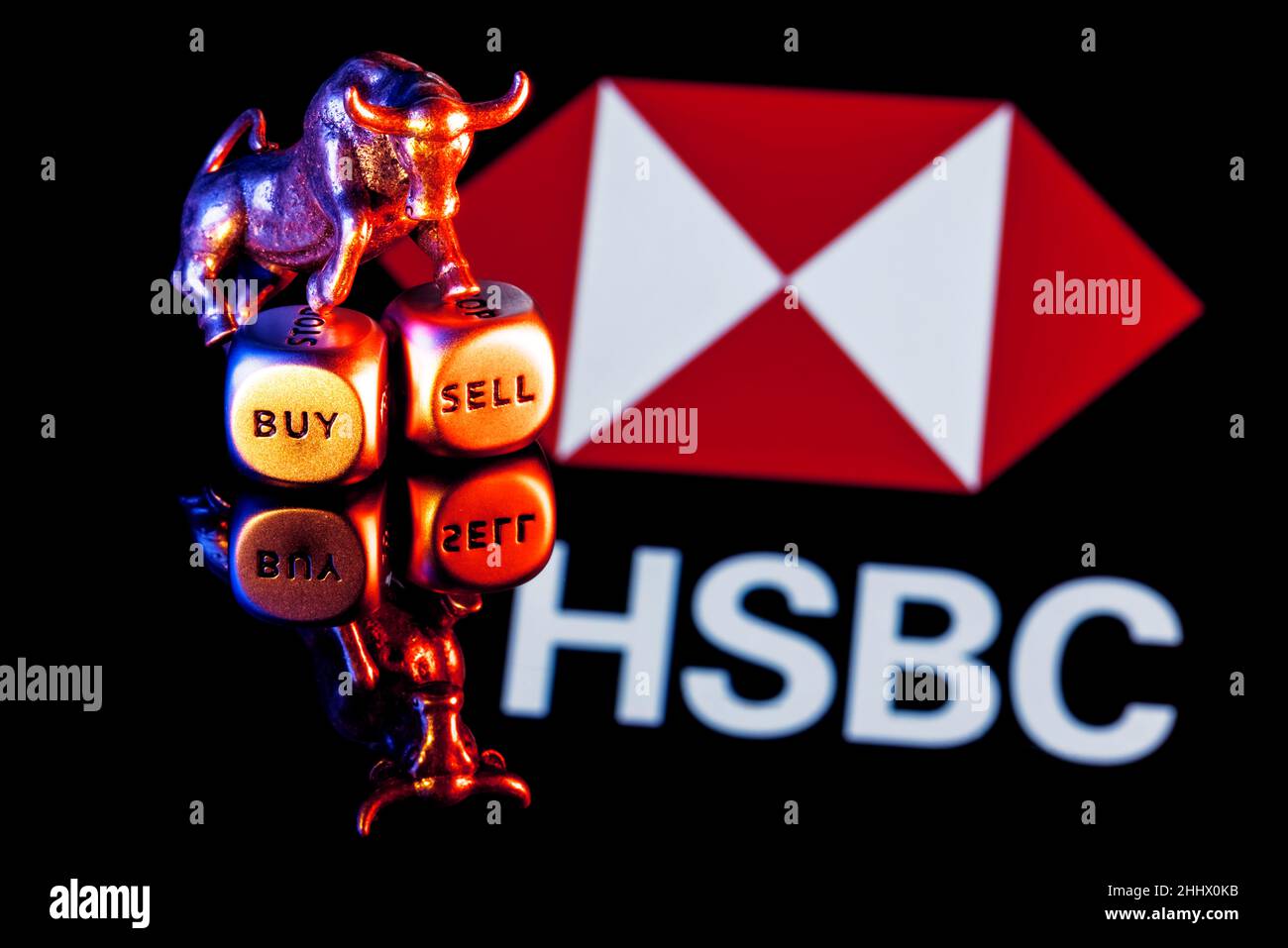 Metal bull stands on buy-sell dices on background of HSBC bank logo ...