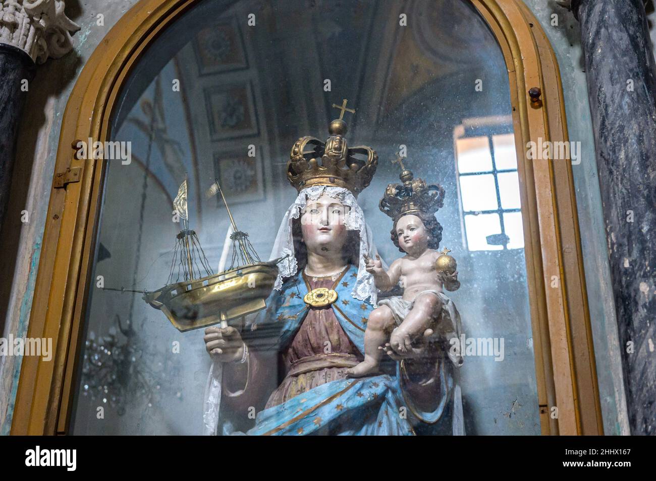 Sculpture of virgin Mary is seen holding a boat as a symbol of ...