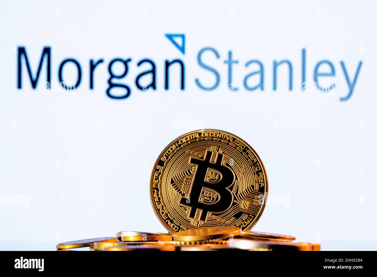Golden bitcoin in a pile of coins on the background of Morgan Stanley ...