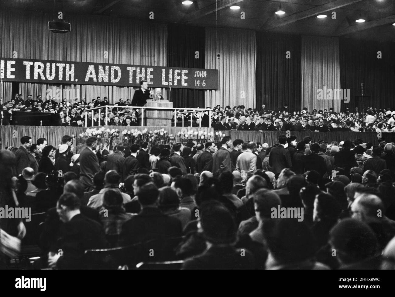American evangelist Billy Graham addressing a huge crowd of people at ...