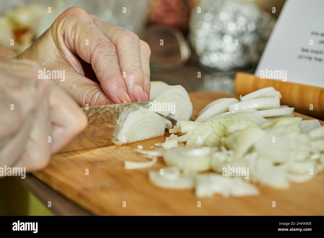 Woman cuts an onion for homemade recipe from the Internet. Prepare ...
