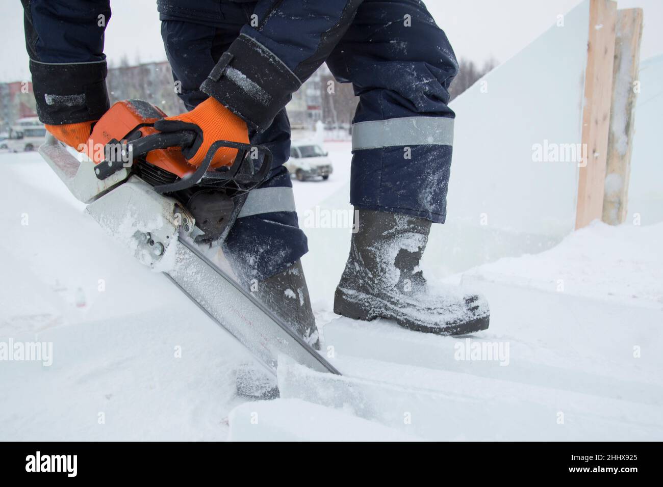Construction worker saws an ice plate with a chainsaw Stock Photo - Alamy