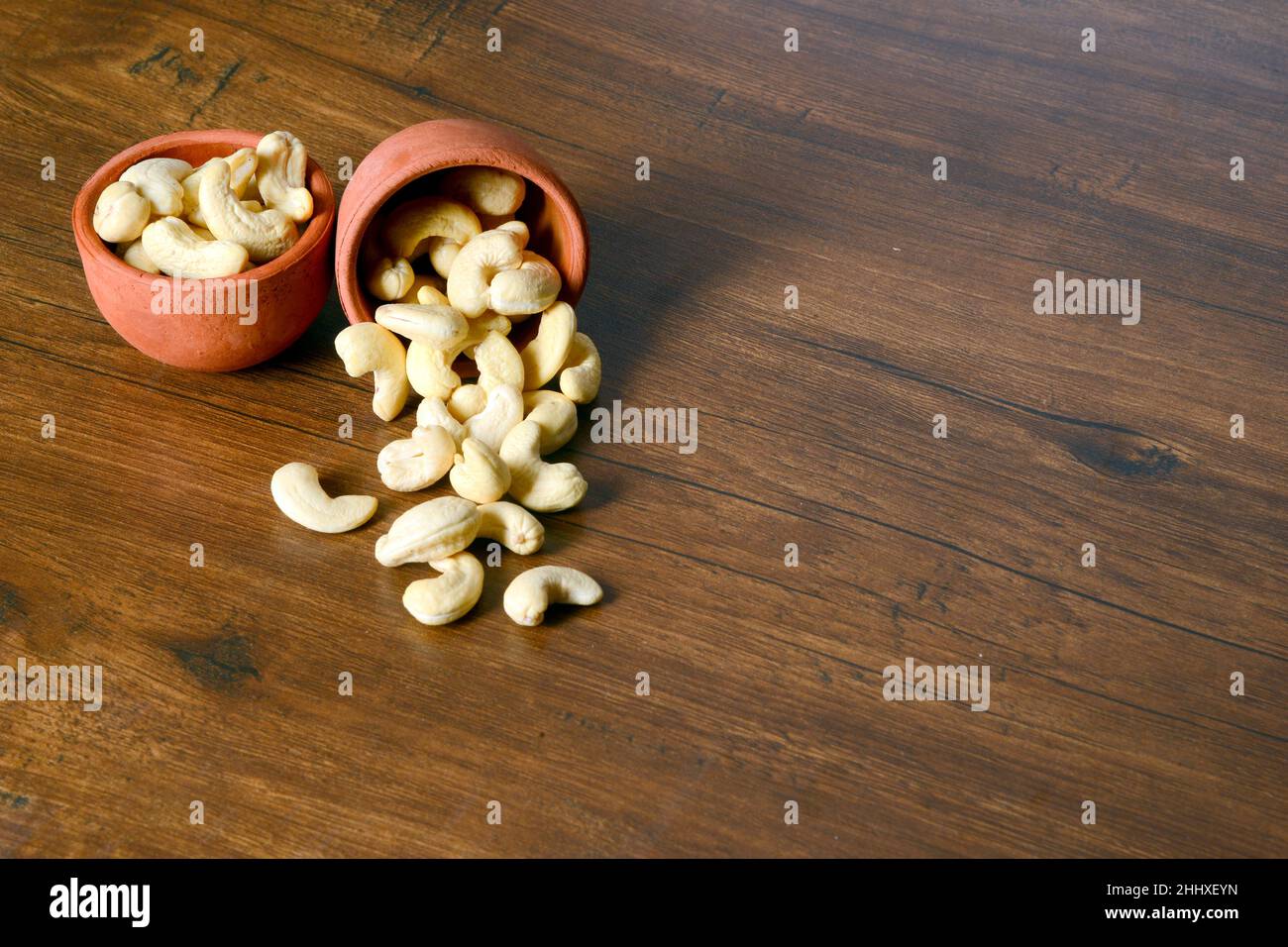 Roasted salted raw cashew nuts in a wooden bowl on a rustic table ...