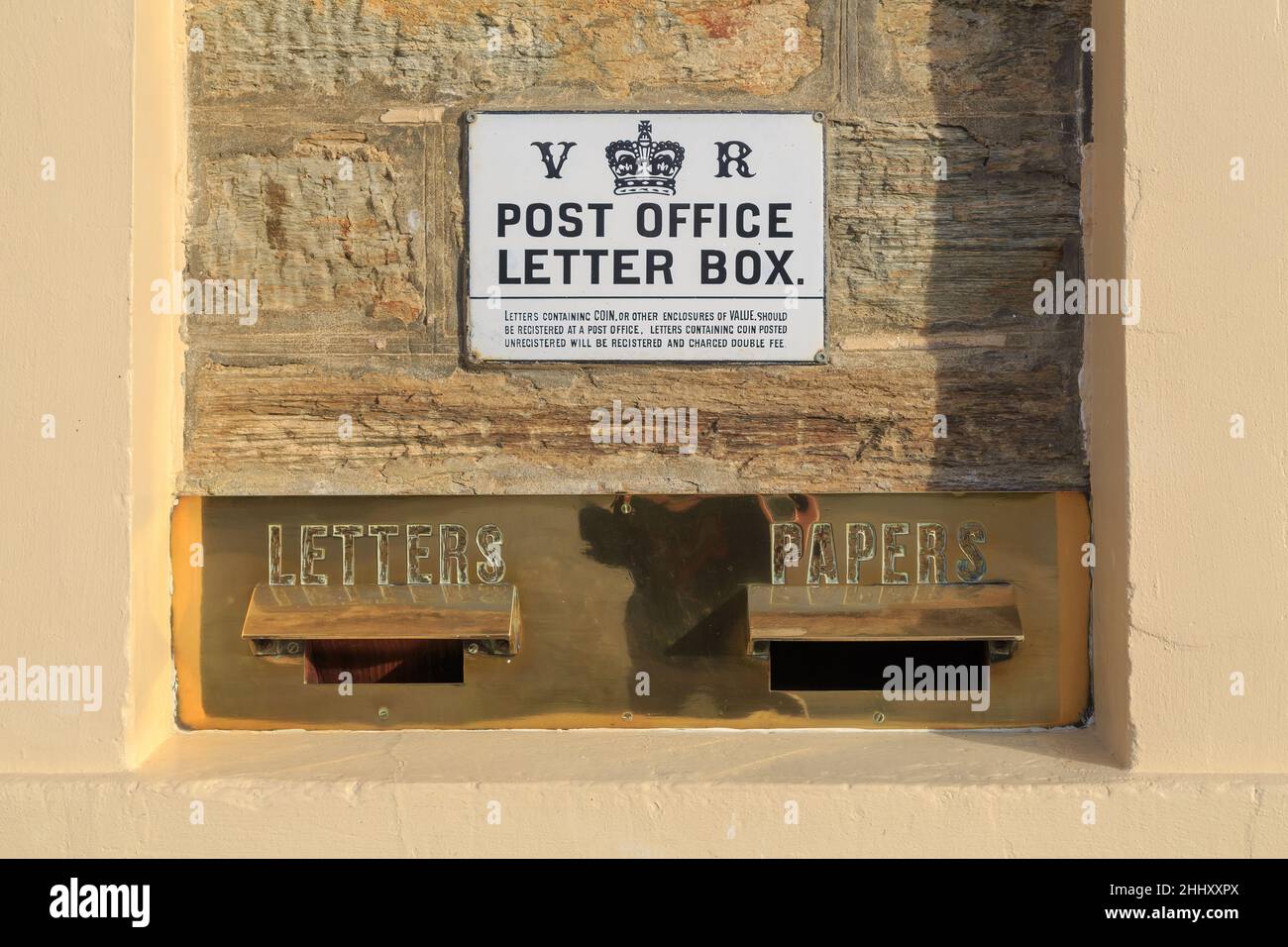 A brass letterbox with the crown and cypher of Queen Victoria ...