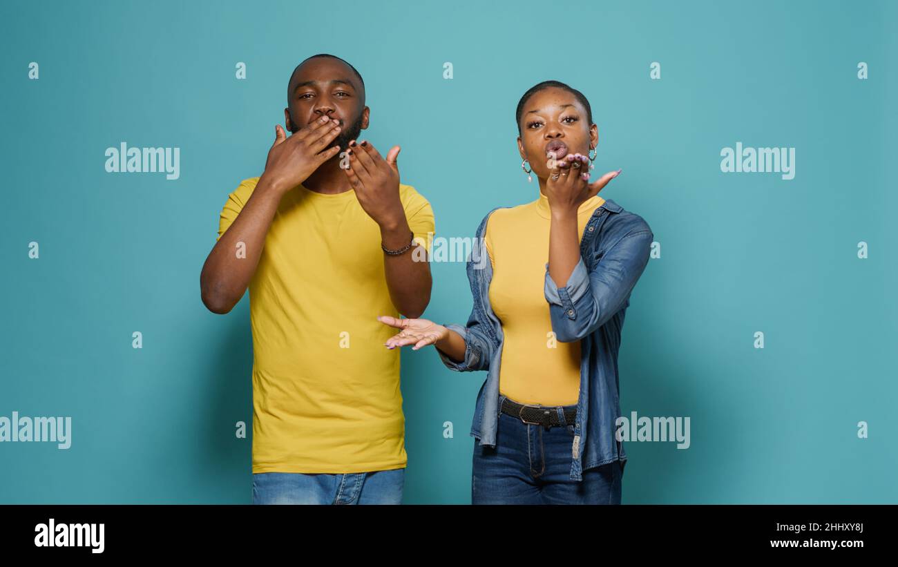 Romantic couple sending air kisses with hands together in front of ...