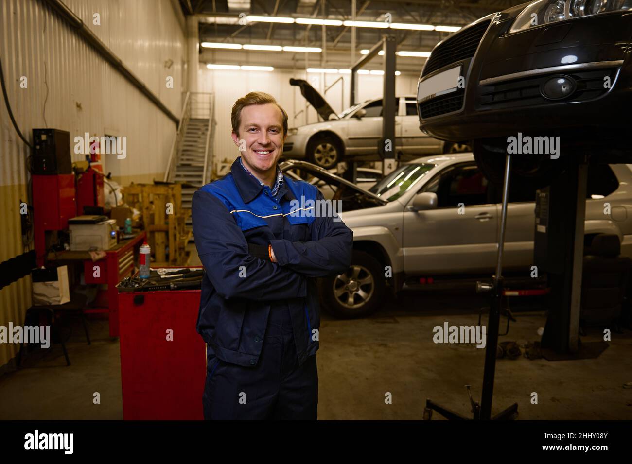 Confident professional portrait of a handsome auto mechanic in uniform ...
