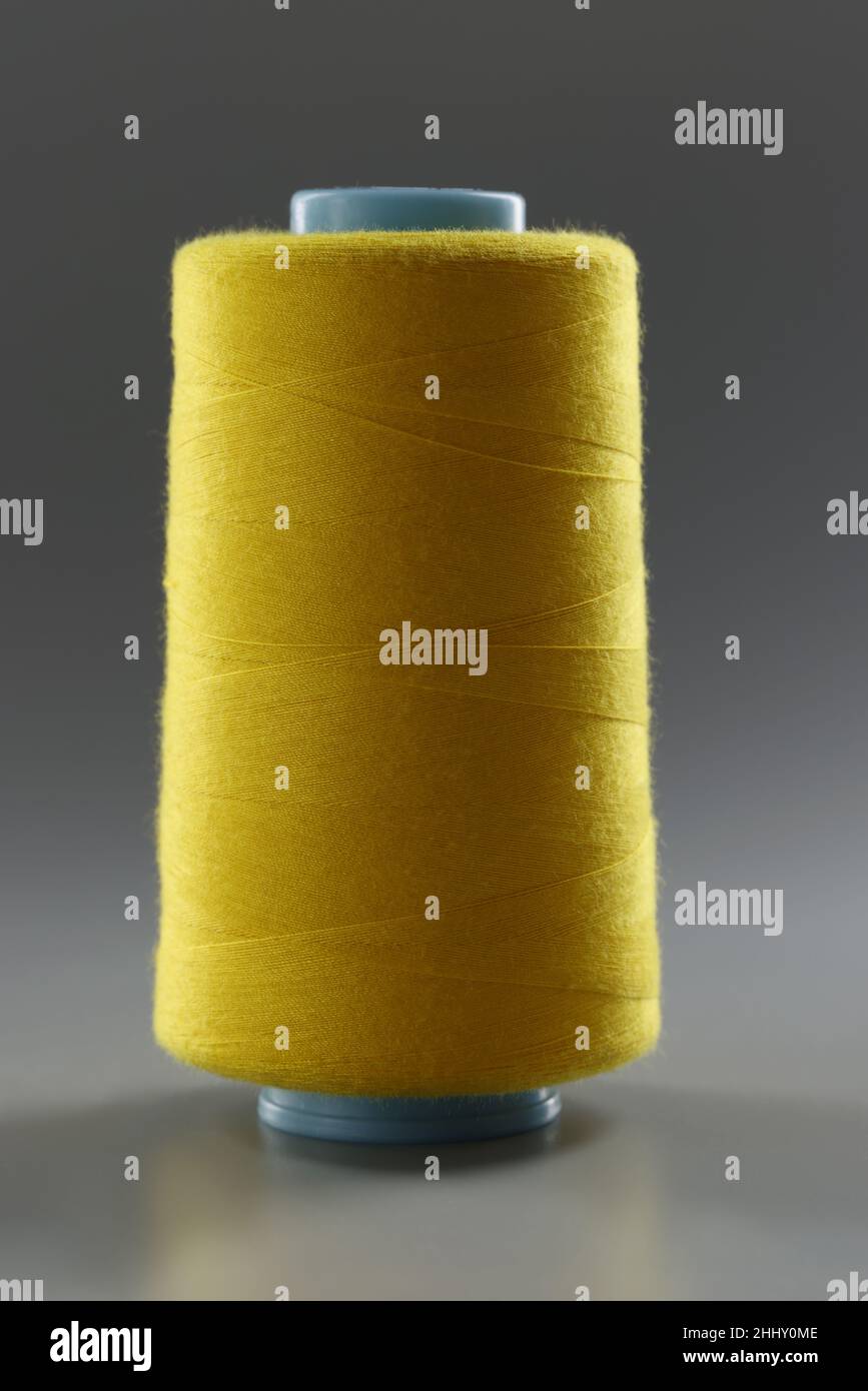 Yellow colour thread spool on grey background, yarn for sewing Stock ...