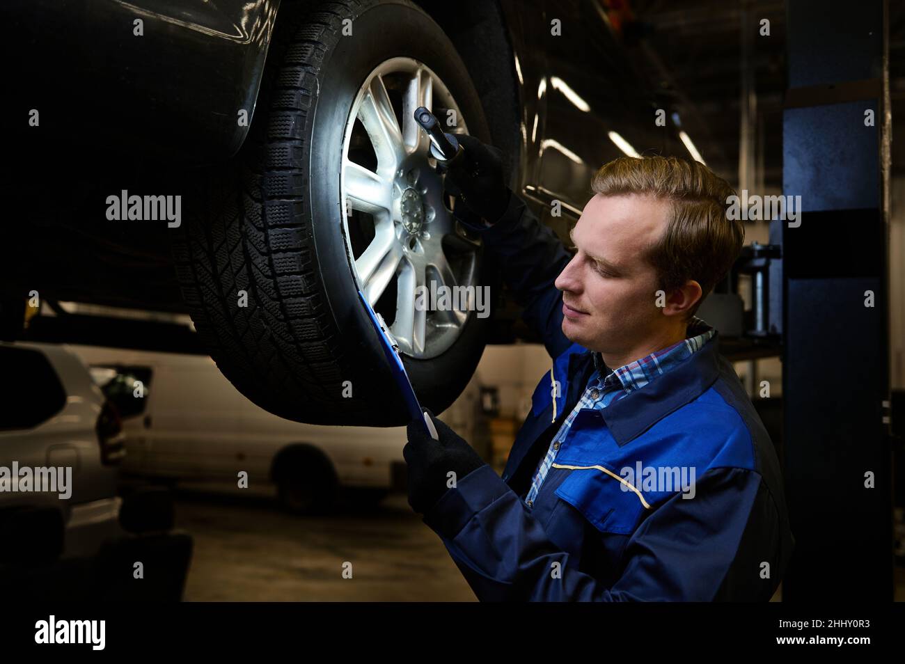 Auto mechanic in an auto repair shop making checklist for repairing a ...