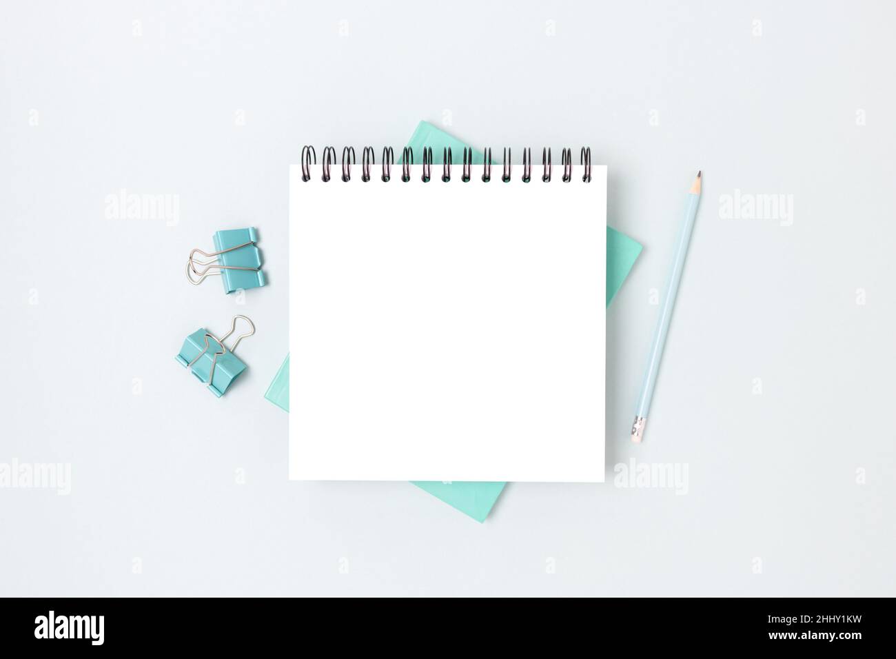 Minimal workspace with square notepad mockup and stationery on a blue ...