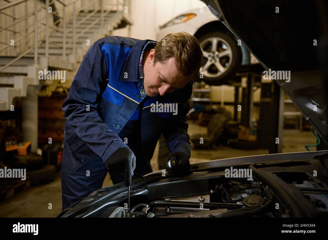 Mechanic checking and repairing car engine, technician inspecting the ...