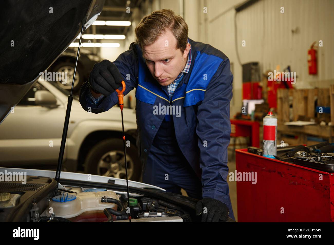 Concentrated Caucasian young man, car engineer technician mechanic in ...