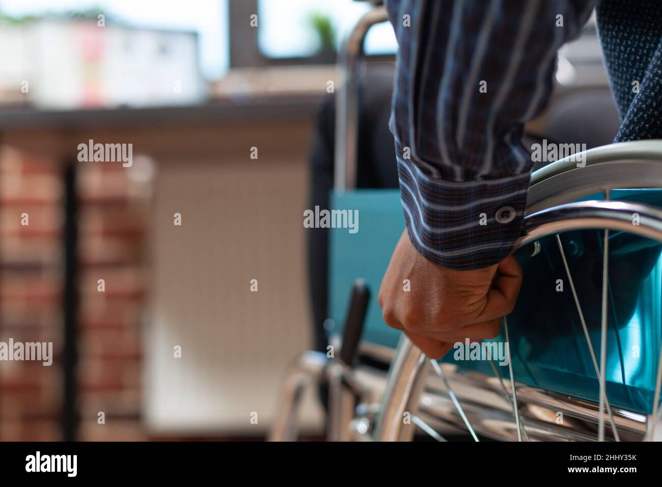 Closeup of startup employee hand holding rim of wheelchair wheel to ...