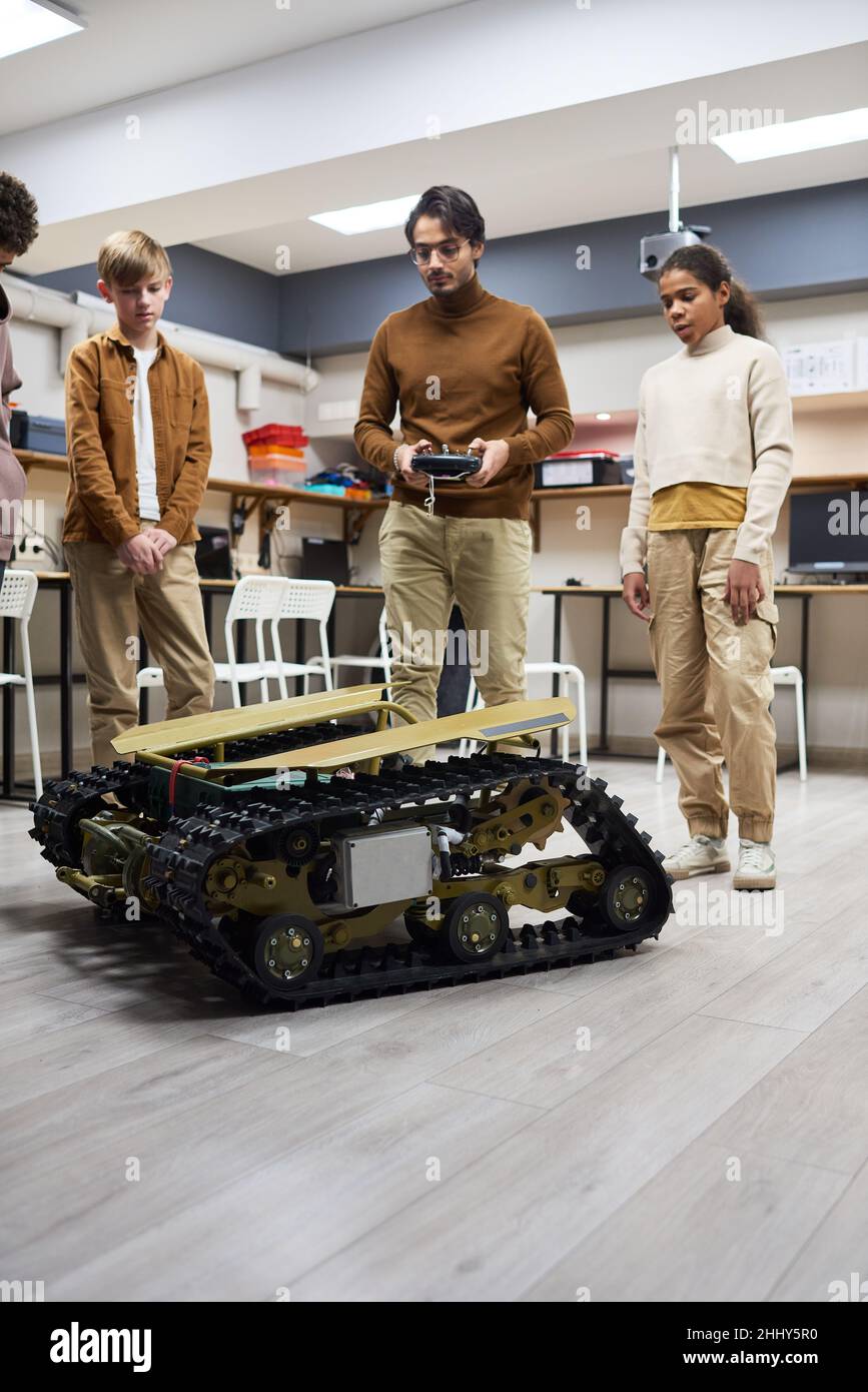 Teacher controlling the big robotic machine with remote control ...