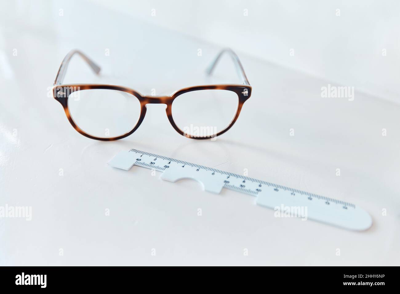 Clarity comes in pairs. Shot of a pair of glasses and a pd ruler in an ...
