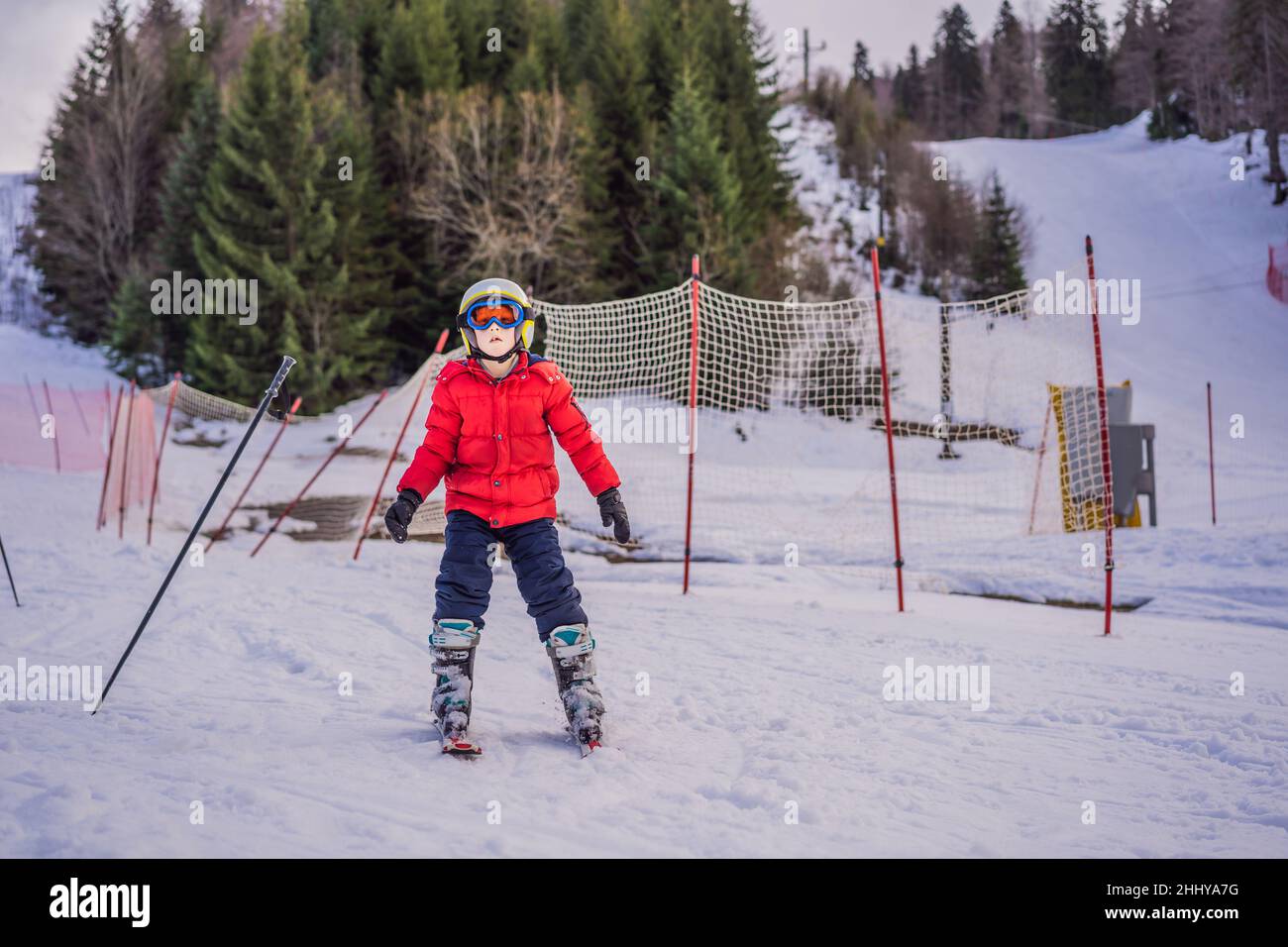 Child skiing in mountains. Active toddler kid with safety helmet ...