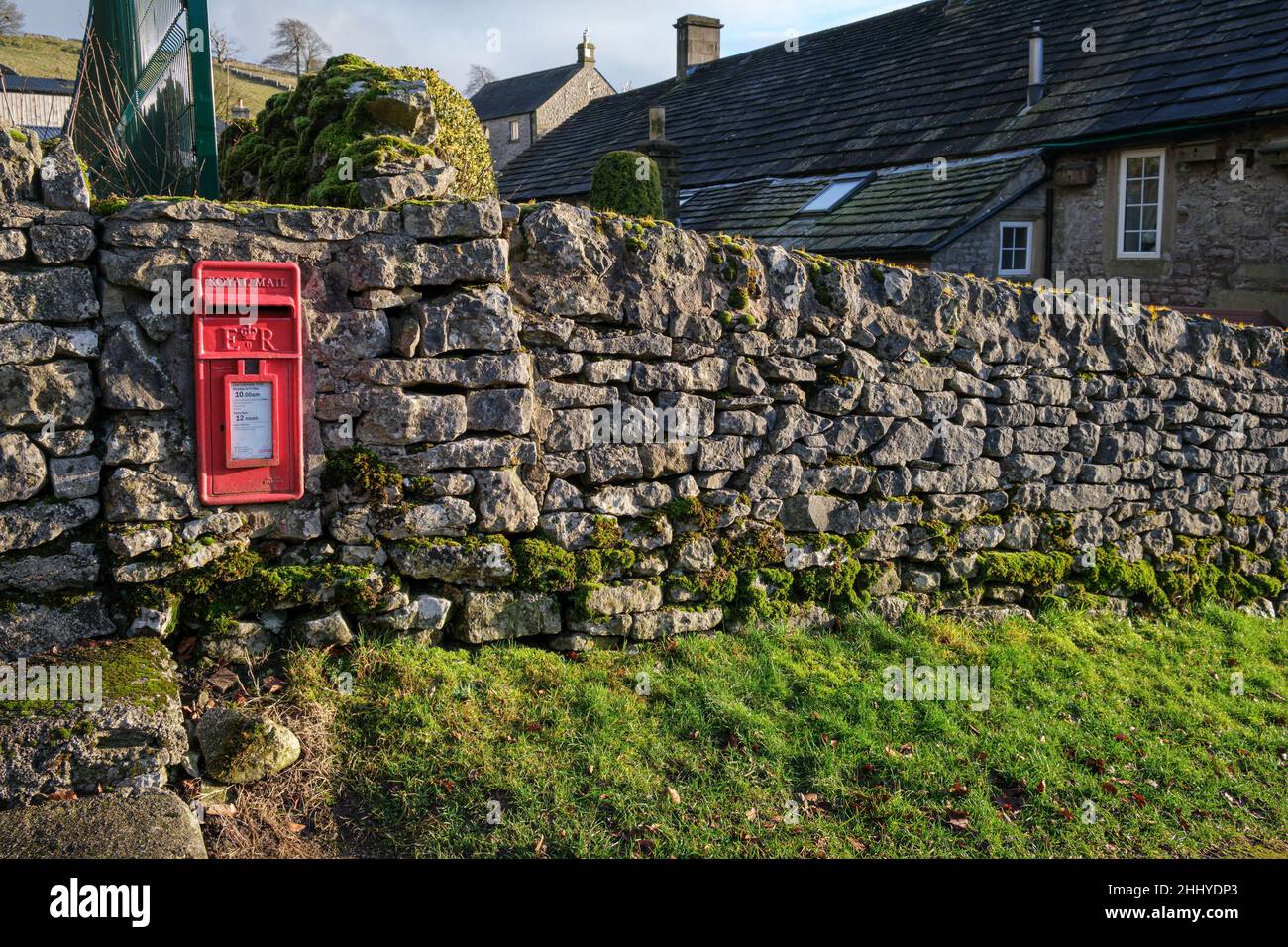 A post box built into a dry stone wall in the Peak District village of ...