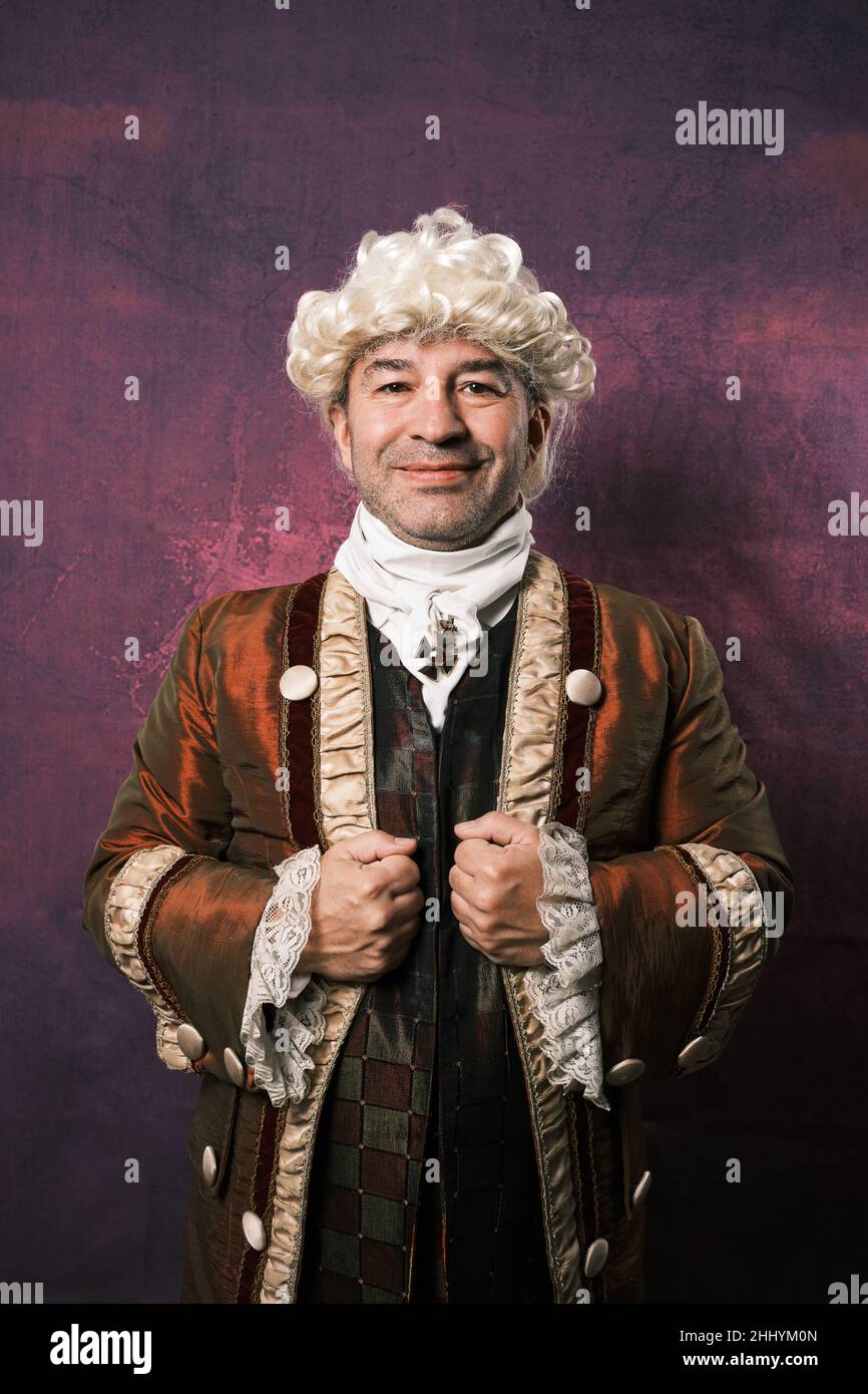 Man in classic medieval clothing smiling while posing holding his suit ...