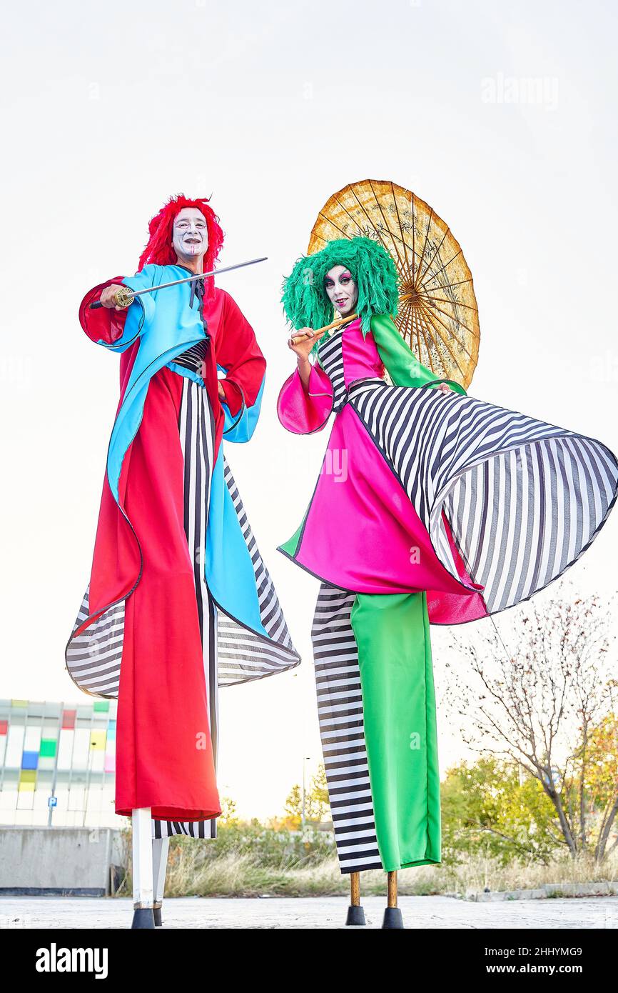 Full length of creative talented performers with face art in colorful ...