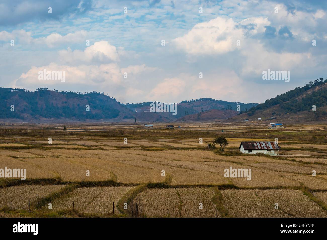 isolated house at countryside farming field surrounded with mountain ...