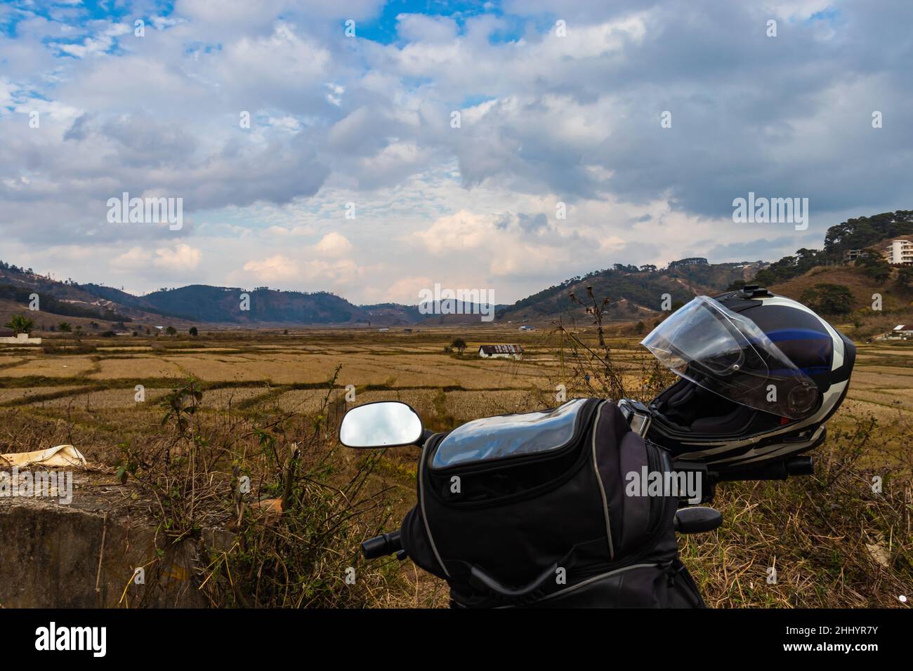 motorcycle view of countryside farming fields surrounded with mountain ...