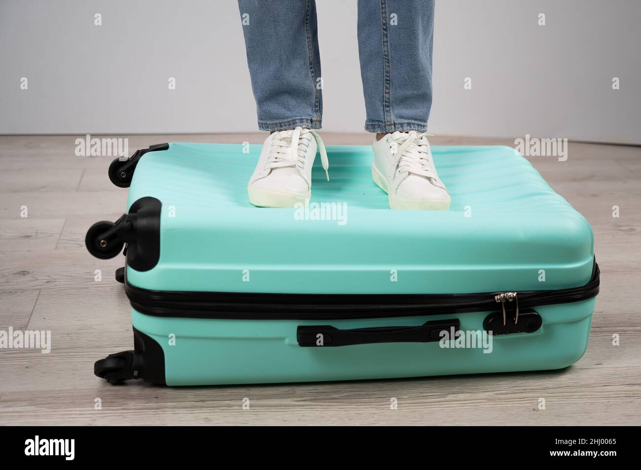 Woman standing with her feet on a suitcase Stock Photo - Alamy