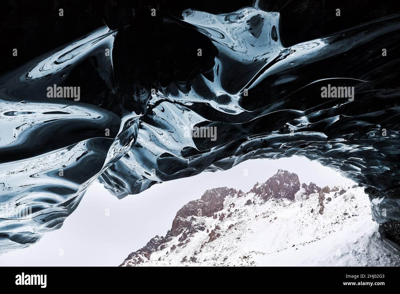 Beautiful landscape of Blue ice cave arch and mountains covered with ...