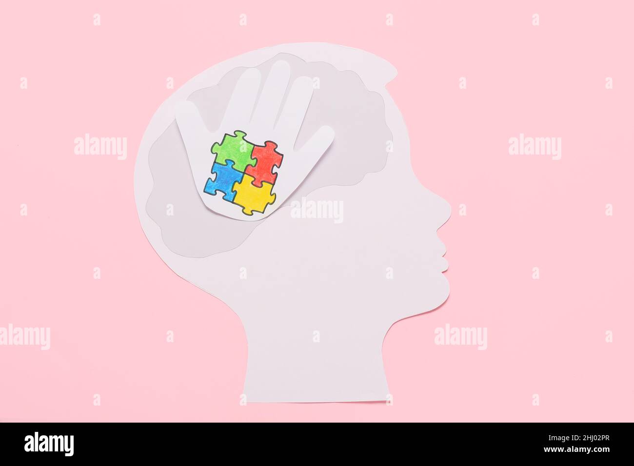 Paper human head with palm and colorful puzzle pieces on color ...