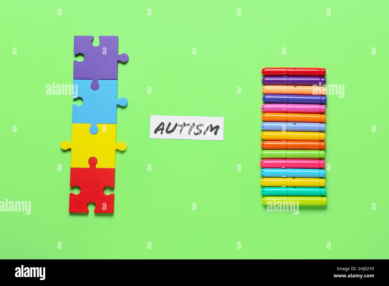 Colorful puzzle pieces and markers with word AUTISM on color background ...