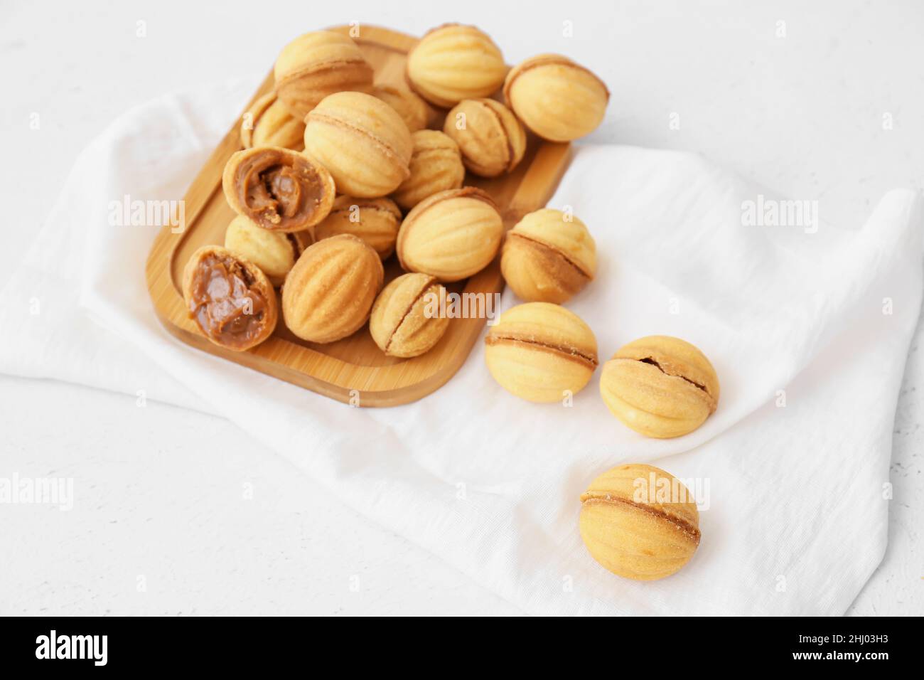 Wooden board of tasty walnut shaped cookies with boiled condensed milk ...