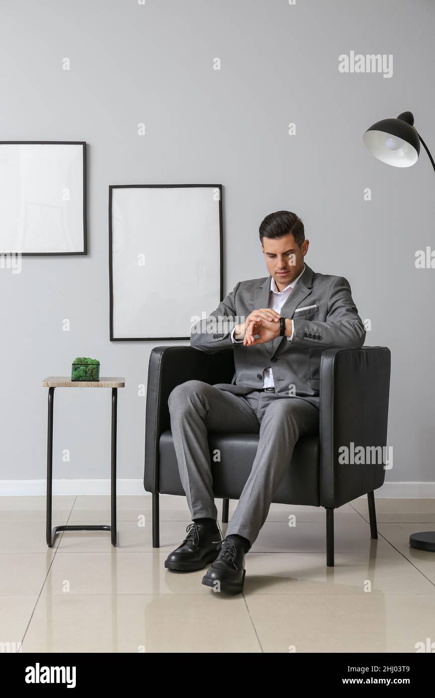 Handsome businessman in armchair checking hi-res stock photography and ...