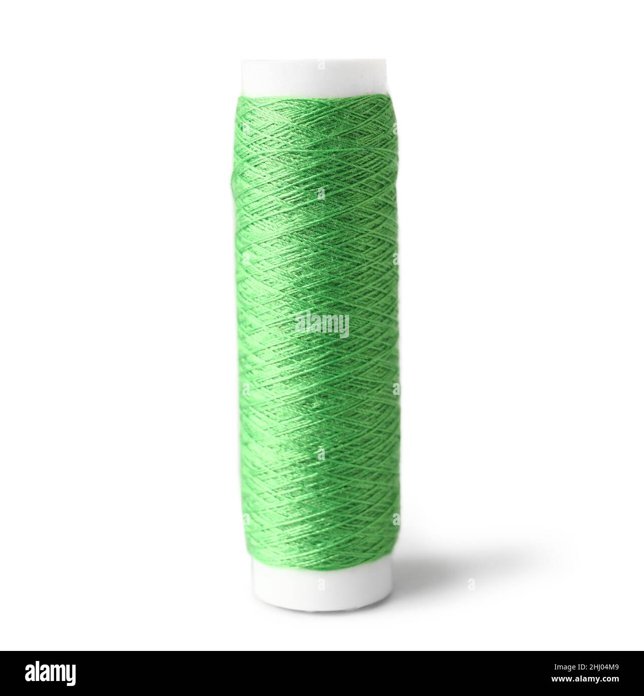 Green sewing thread spool on light background Stock Photo - Alamy