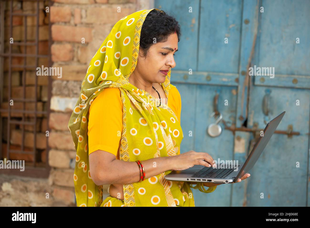 Young traditional indian woman using laptop. female wearing sari ...