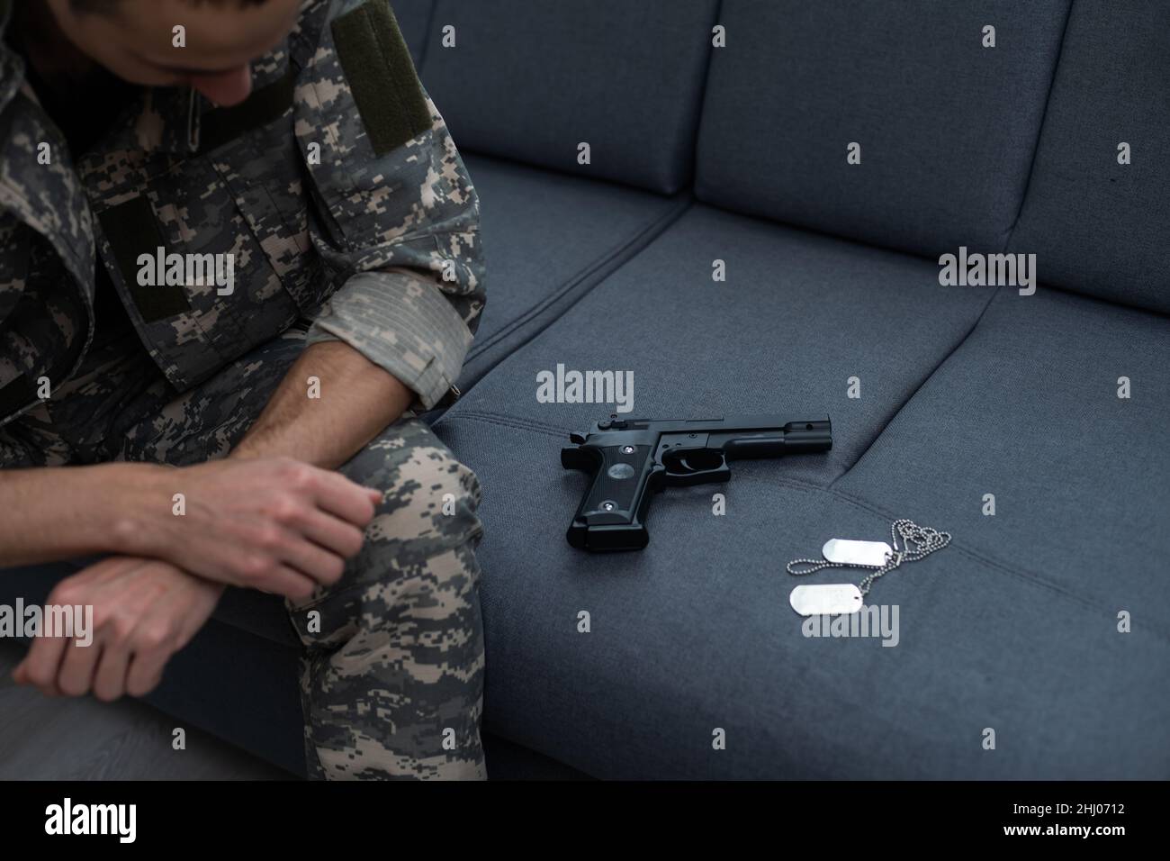 Sad solider sitting with a gun Stock Photo - Alamy