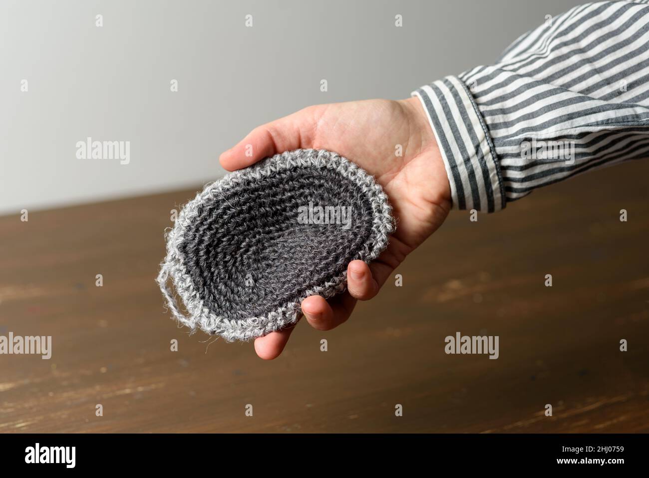 Hand holding natural reusable handmade knitted jute wash cloth Stock ...