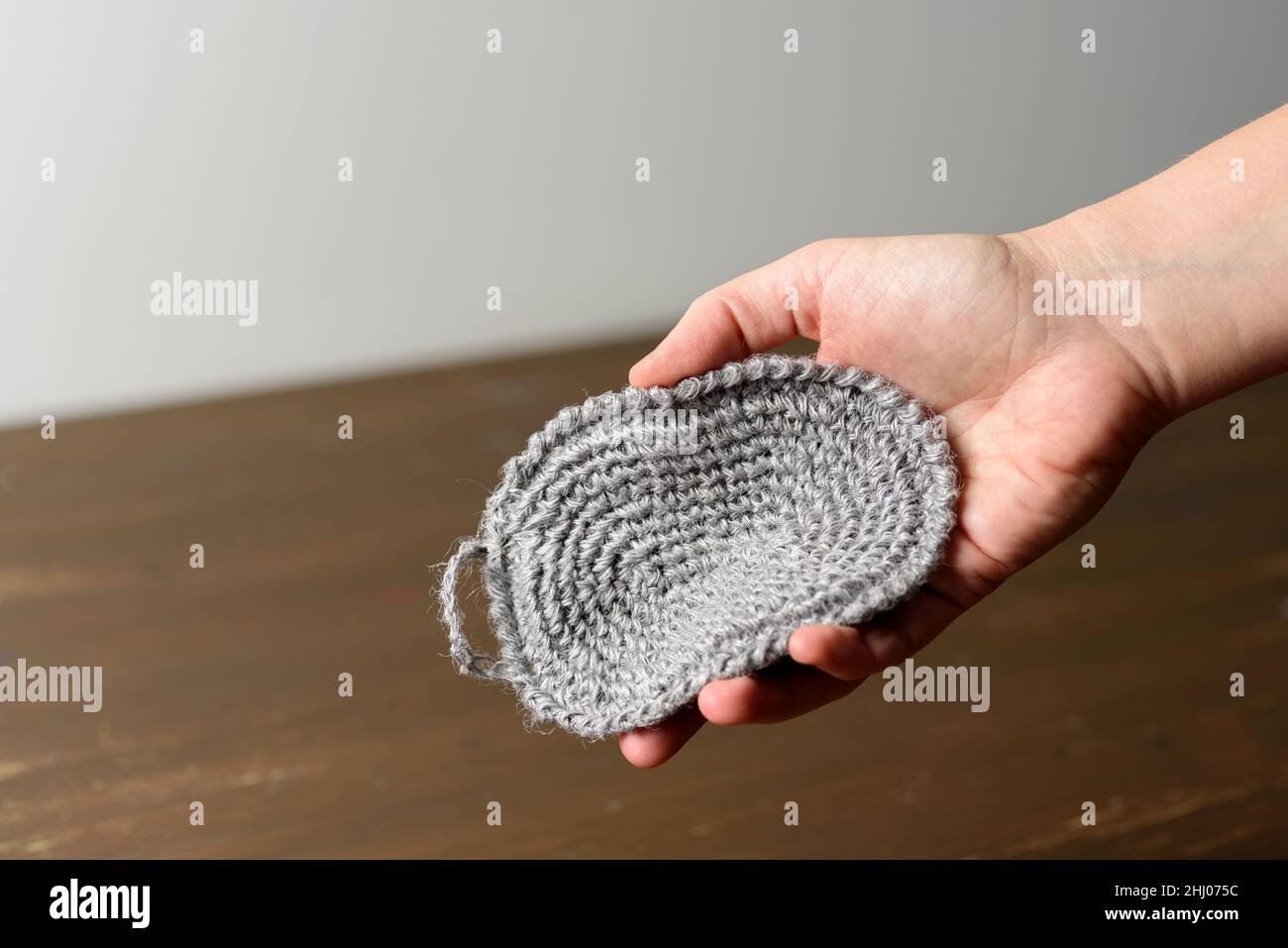 Hand holding natural reusable handmade knitted jute wash cloth Stock ...