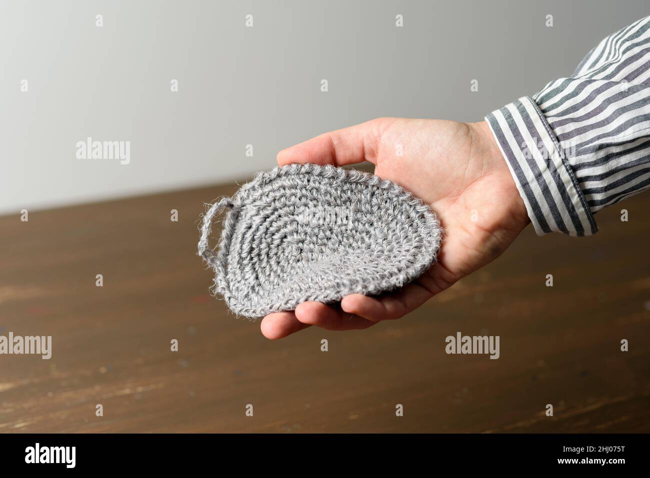 Hand holding natural reusable handmade knitted jute wash cloth Stock ...