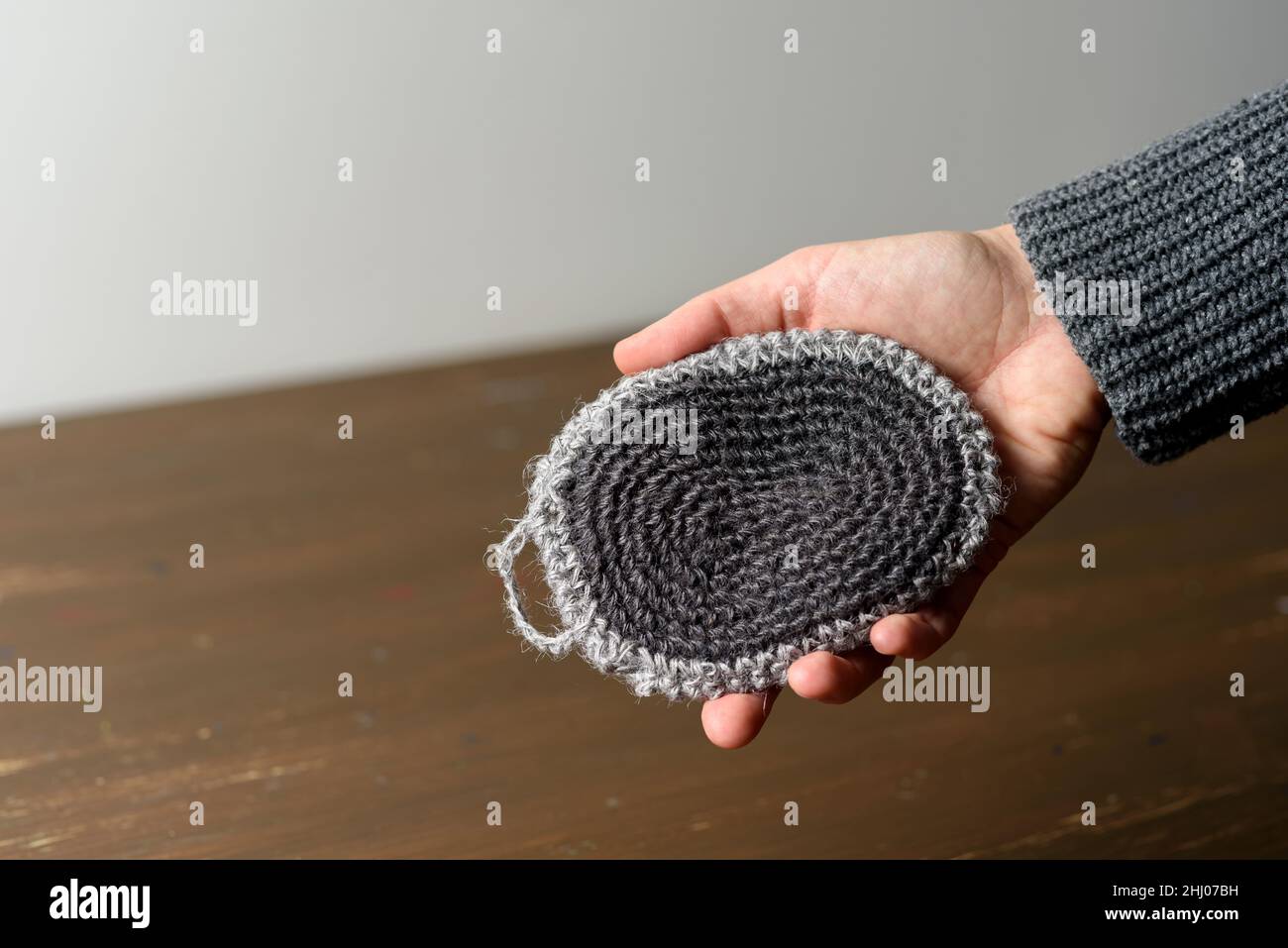 Hand holding natural reusable handmade knitted jute wash cloth Stock ...