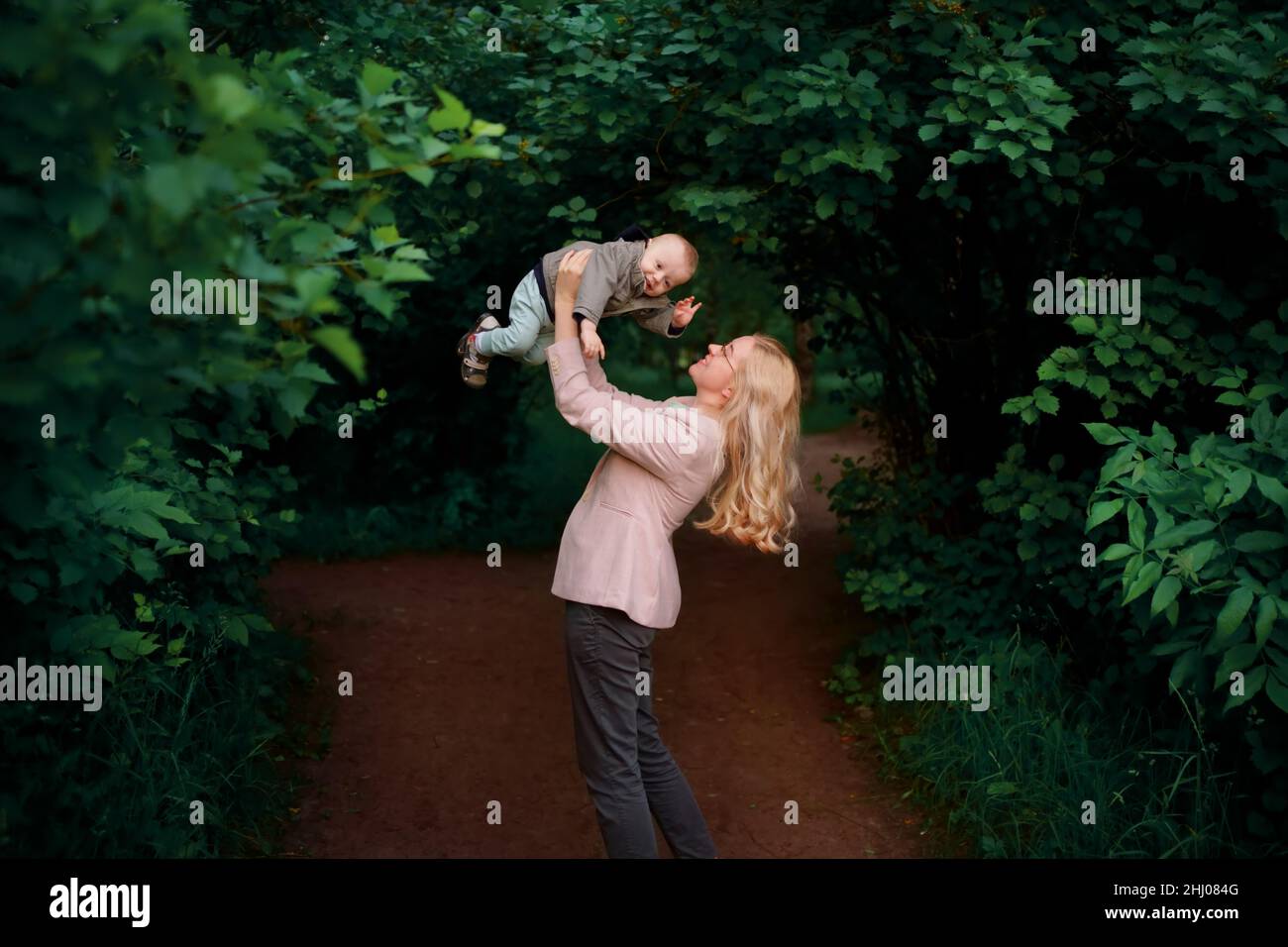 mother raised the child high in her arms, he is happy Stock Photo - Alamy
