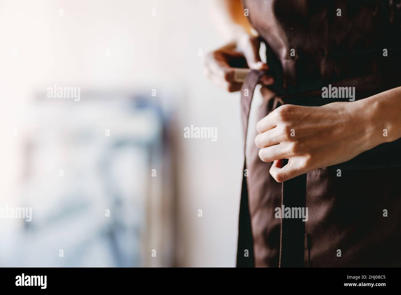 Black student woman wearing apron during class in art school indoors ...