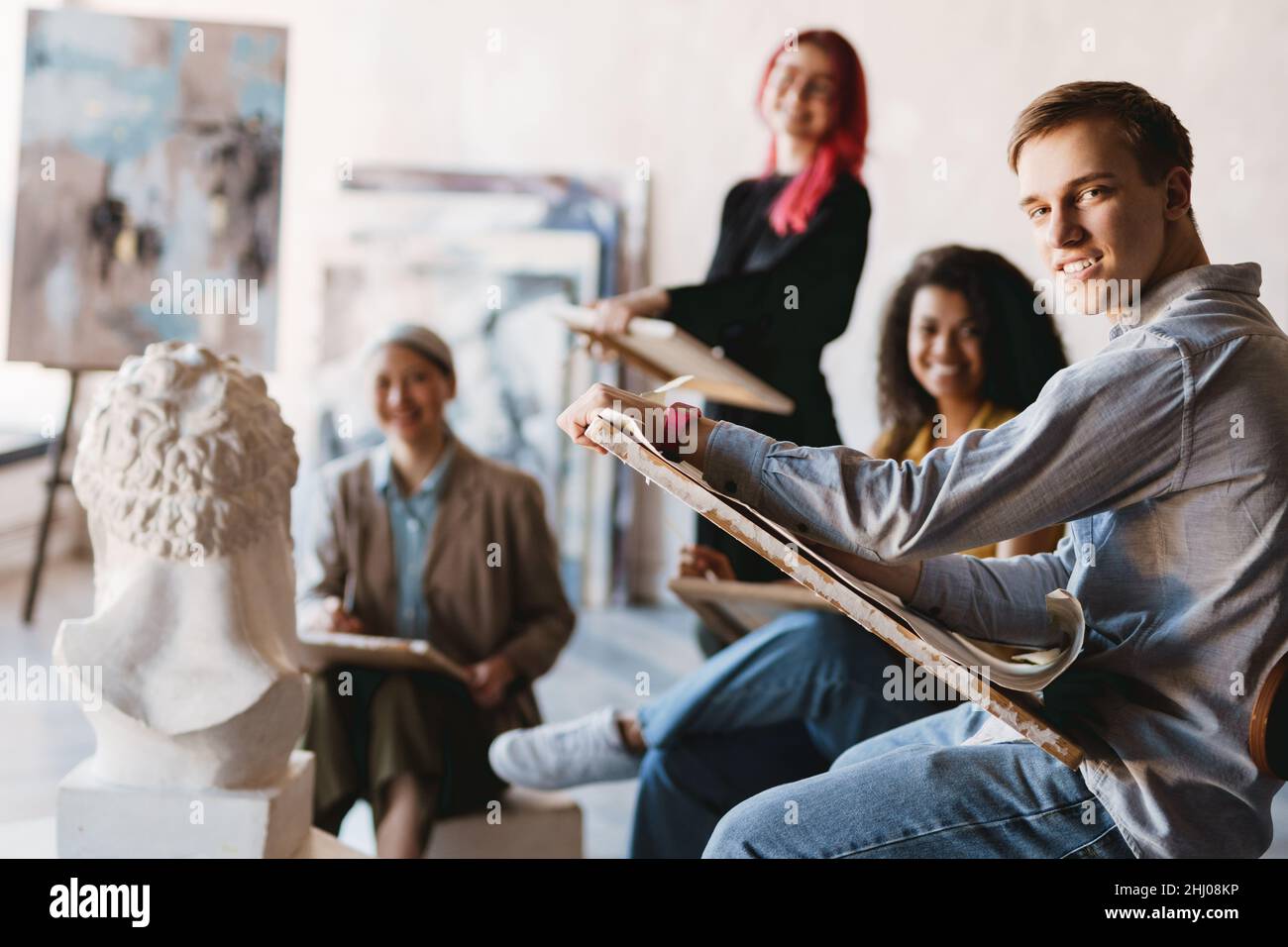 Young multiracial students drawing plaster bust during class in art ...