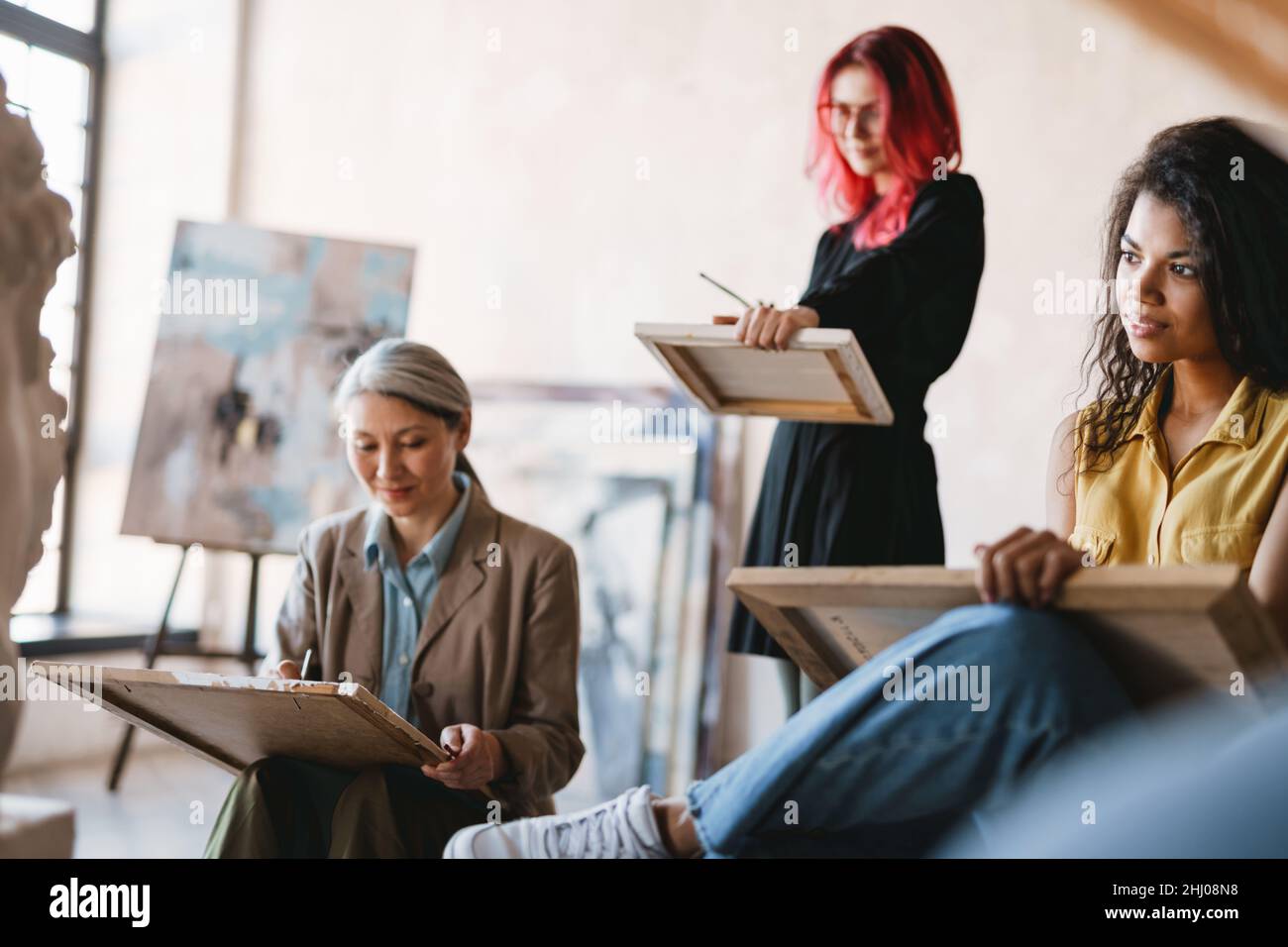 Young multiracial students drawing plaster bust during class in art ...