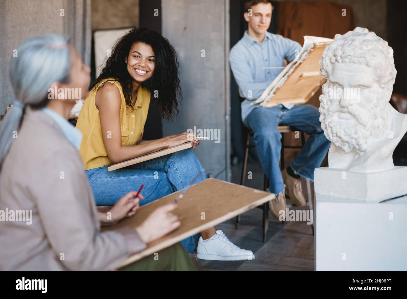 Young multiracial students drawing plaster bust during class in art ...
