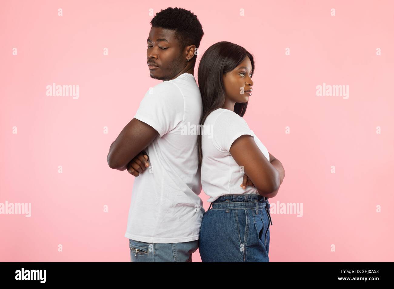 Black couple standing back to back, pink studio wall Stock Photo - Alamy