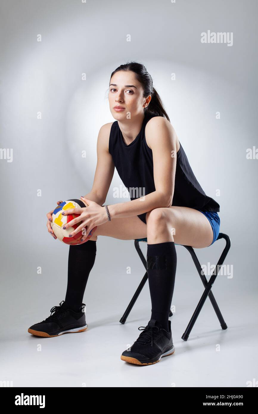 Handball player sitting on a chair. Female posing with ball Stock Photo ...